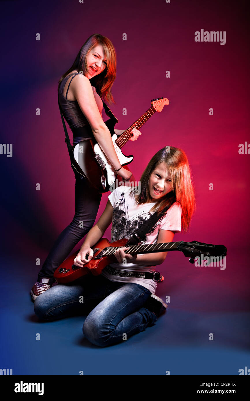 portrait of two young girls with a guitar on the stage Stock Photo - Alamy