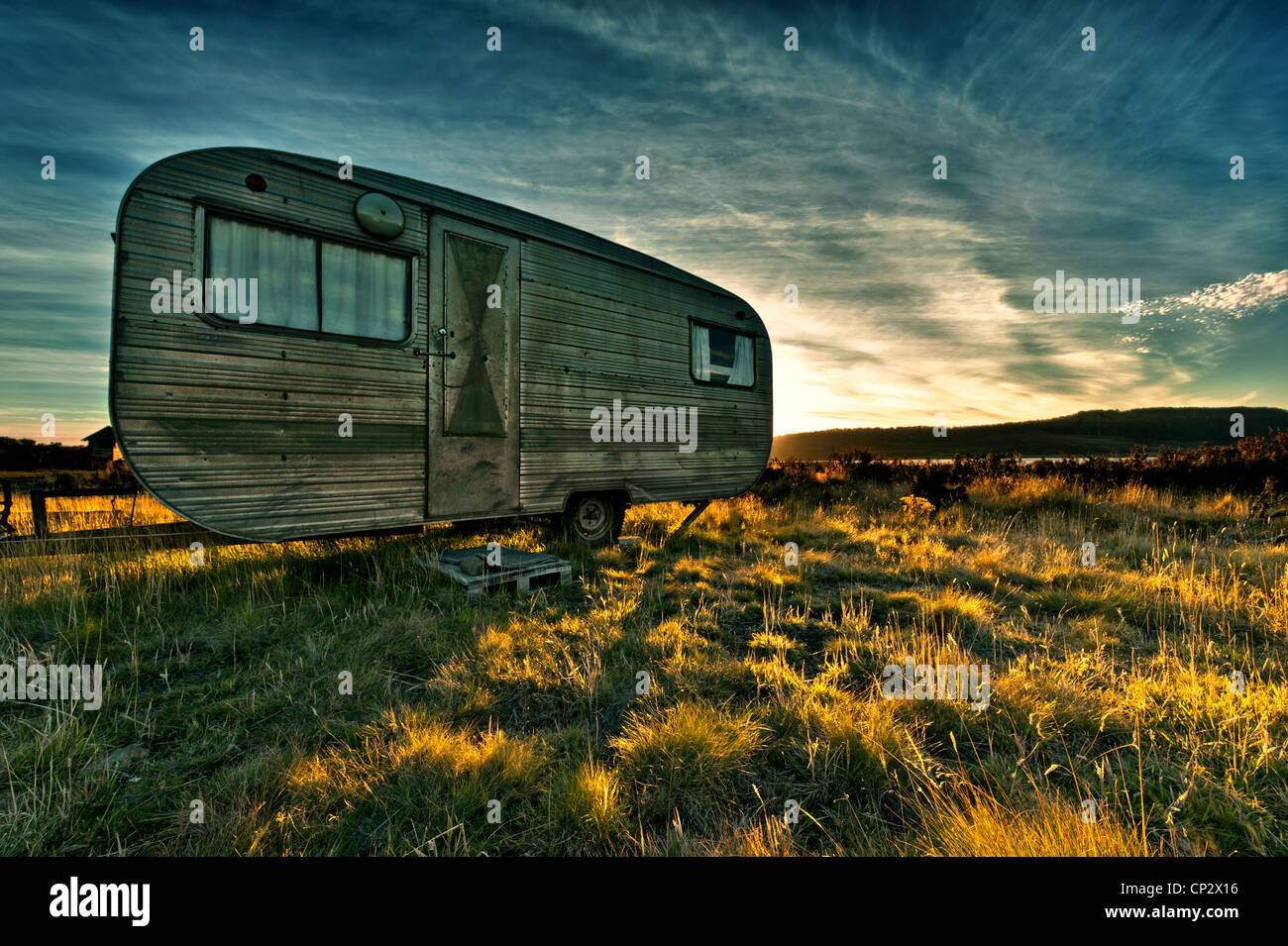 Camper trailer backlit by the sun during a beautiful sunset Stock Photo ...