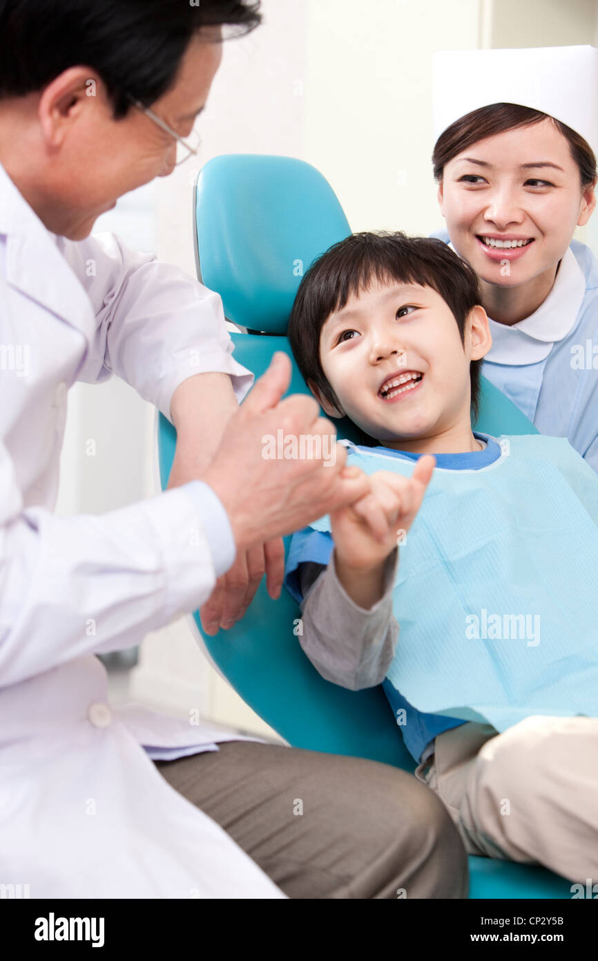 Dentist making promise with a little patient Stock Photo - Alamy