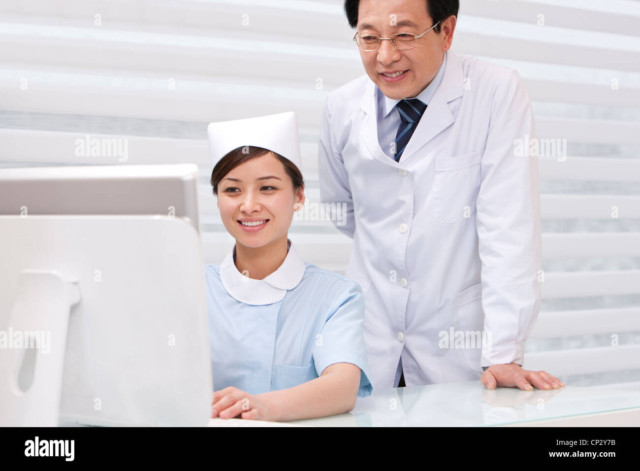 Doctor and nurse using computer in hospital Stock Photo - Alamy