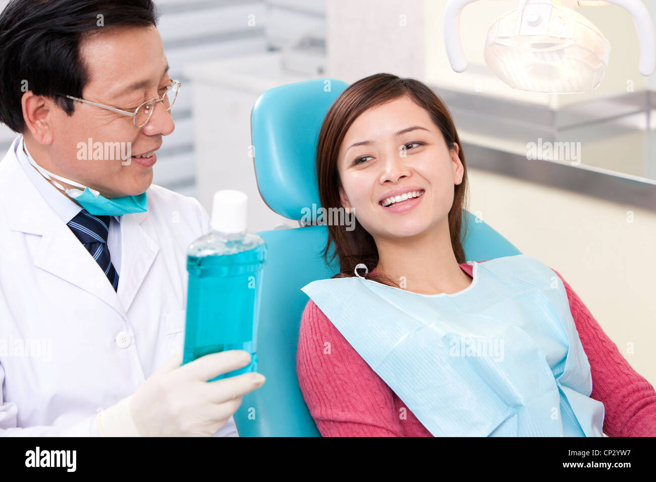 Dentist introducing mouth wash to patient Stock Photo - Alamy