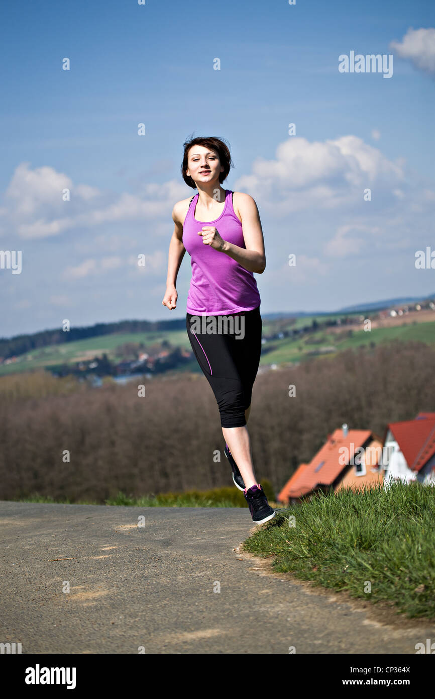 A woman jogging in front of cross country Stock Photo - Alamy