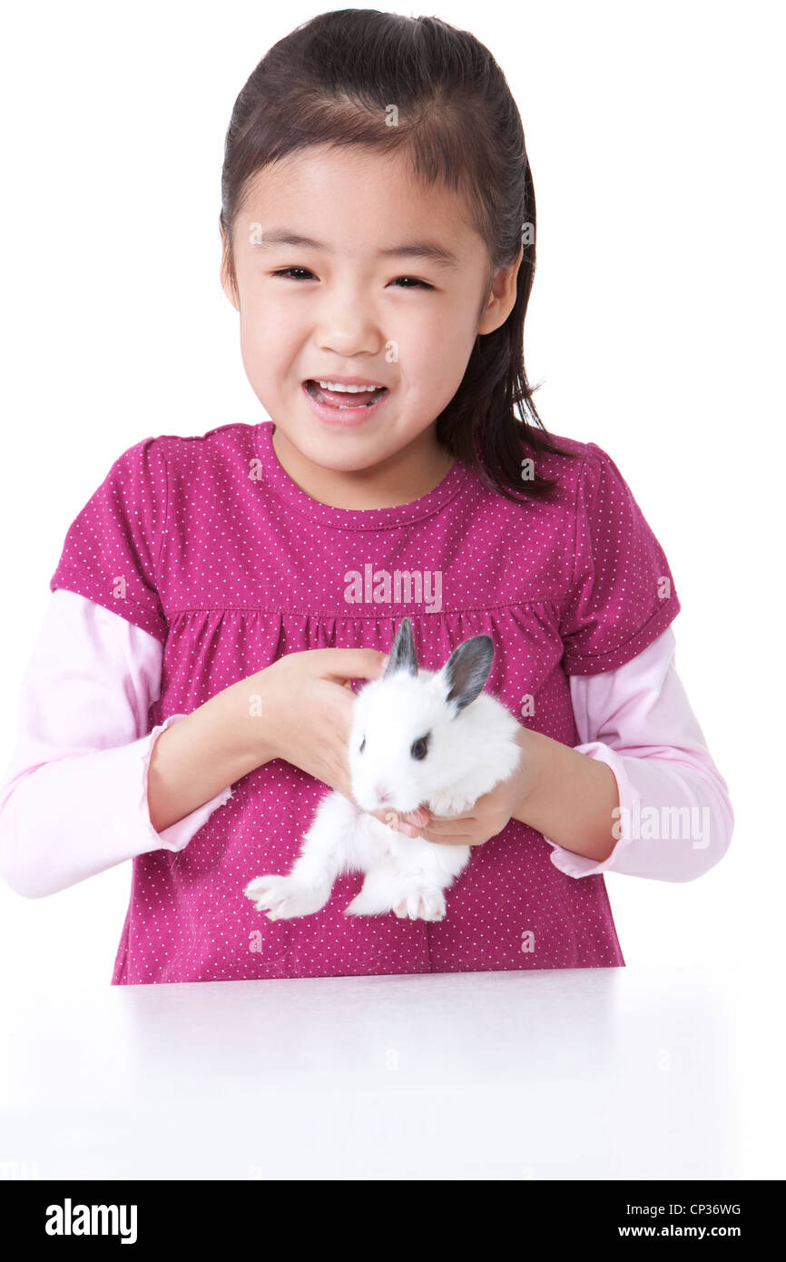 Little girl playing with rabbit Stock Photo - Alamy