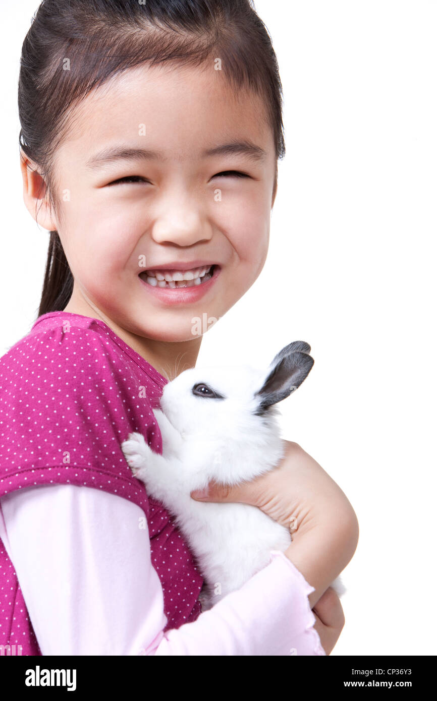Little girl playing with rabbit Stock Photo - Alamy