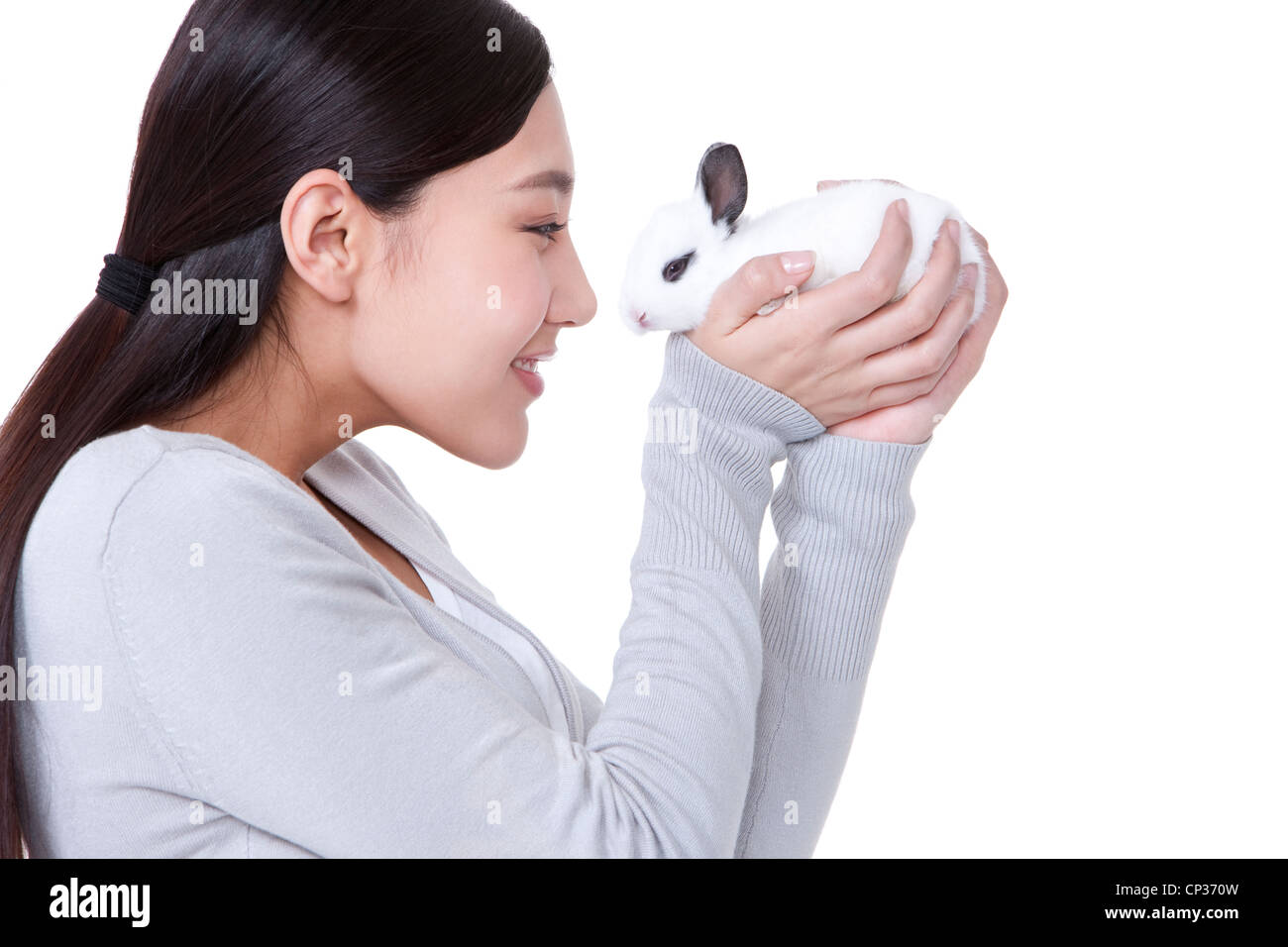 Young woman playing with rabbit Stock Photo - Alamy