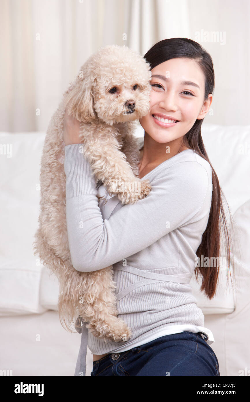 Young woman playing with a pet toy poodle Stock Photo - Alamy