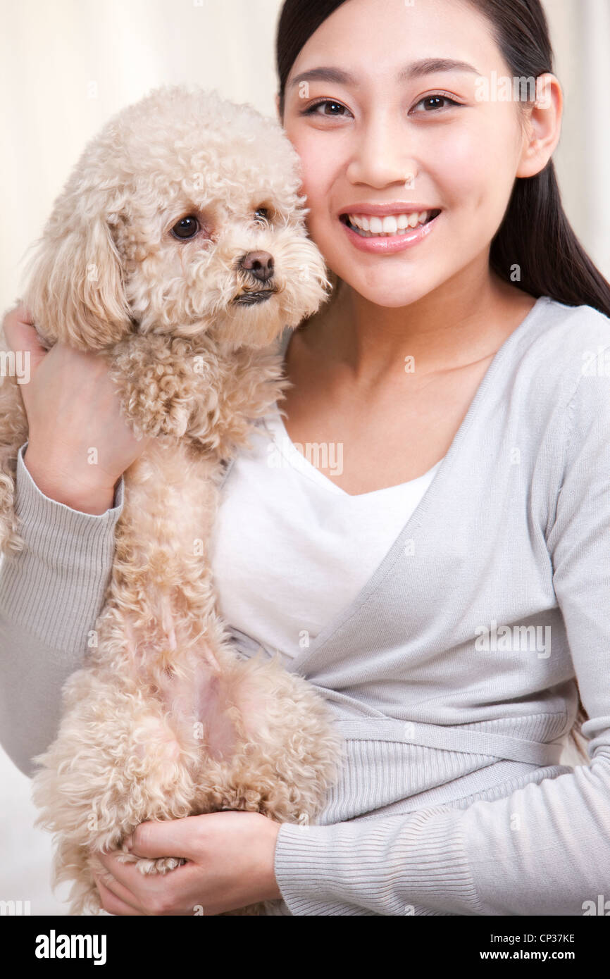 Young woman playing with a pet toy poodle Stock Photo - Alamy