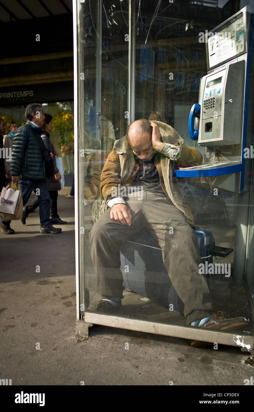 Urban poverty, The old man of the phone booth Stock Photo - Alamy