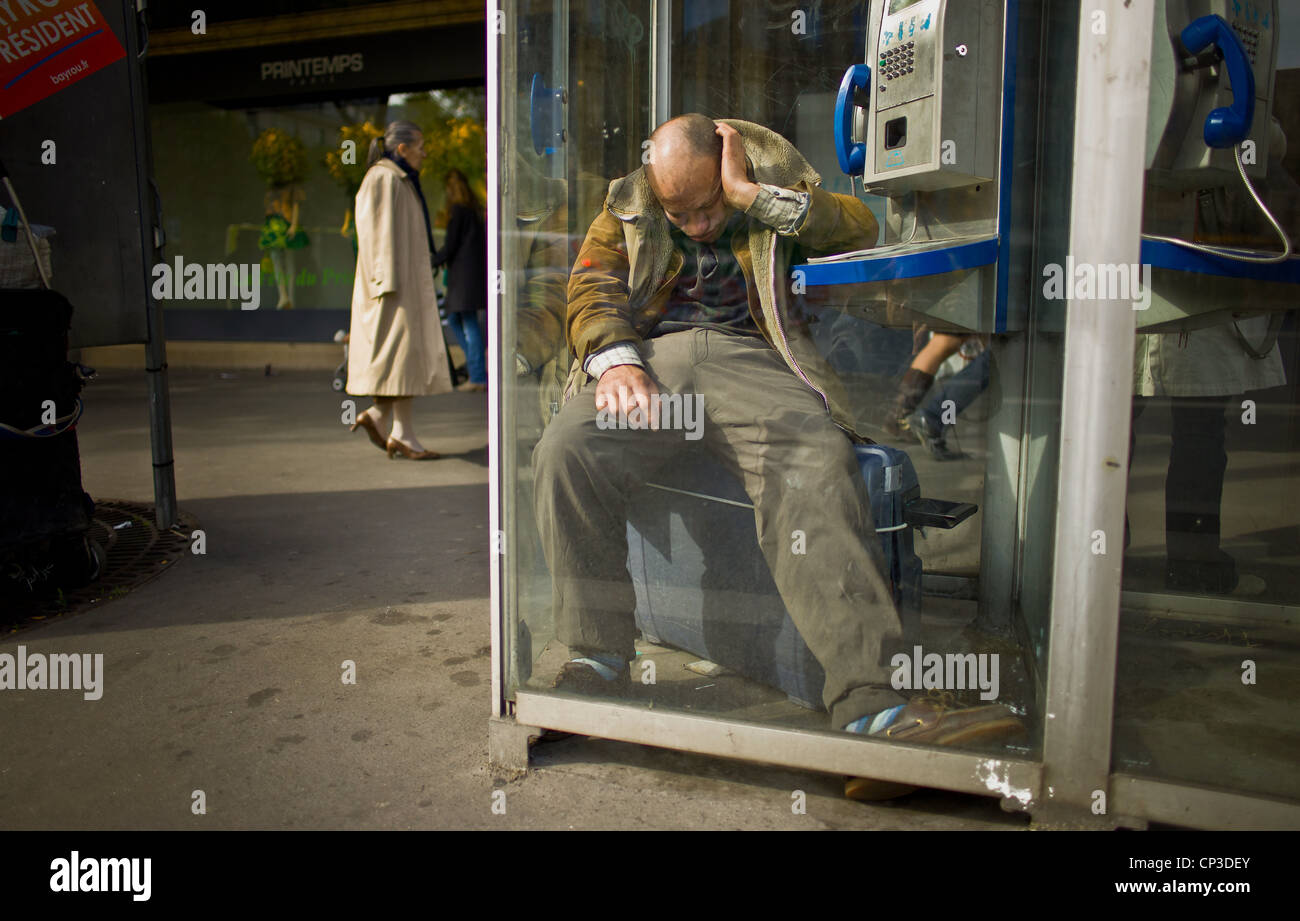 Urban poverty, The old man of the phone booth Stock Photo - Alamy