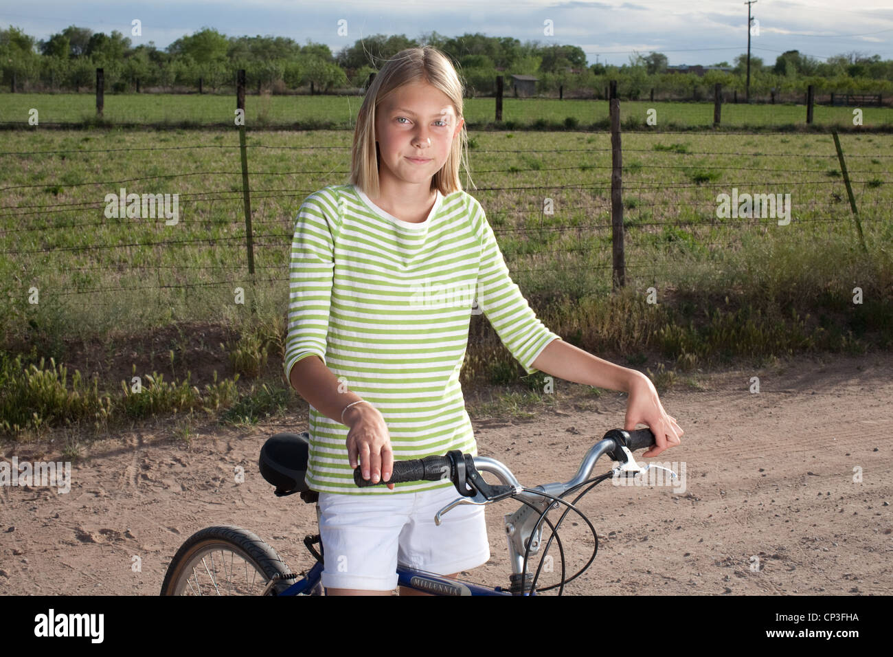 Eleven year old girl getting ready to ride her bike in a rural area ...