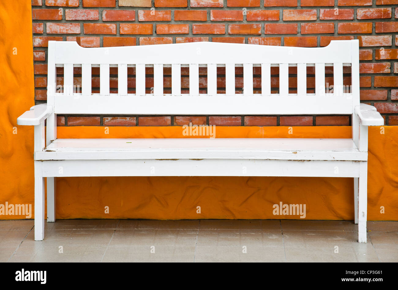 The bench white and against brick wall Stock Photo - Alamy