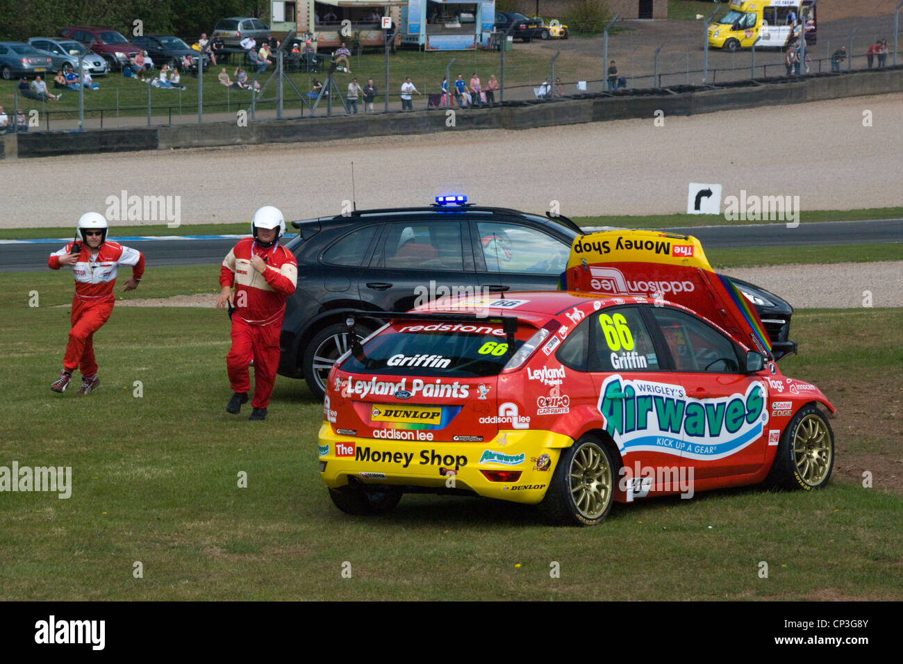Paramedics run to a crashed racing car Stock Photo - Alamy