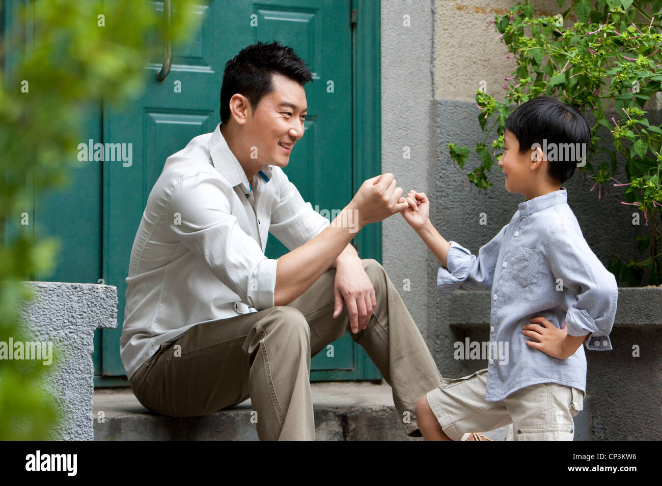 Young Chinese father and son on front stoop Stock Photo - Alamy