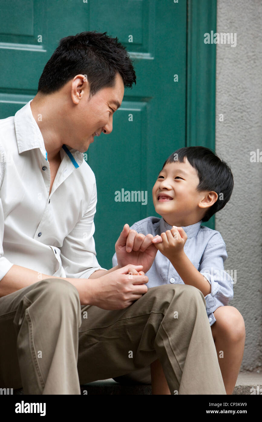 Young Chinese father and son on front stoop Stock Photo - Alamy