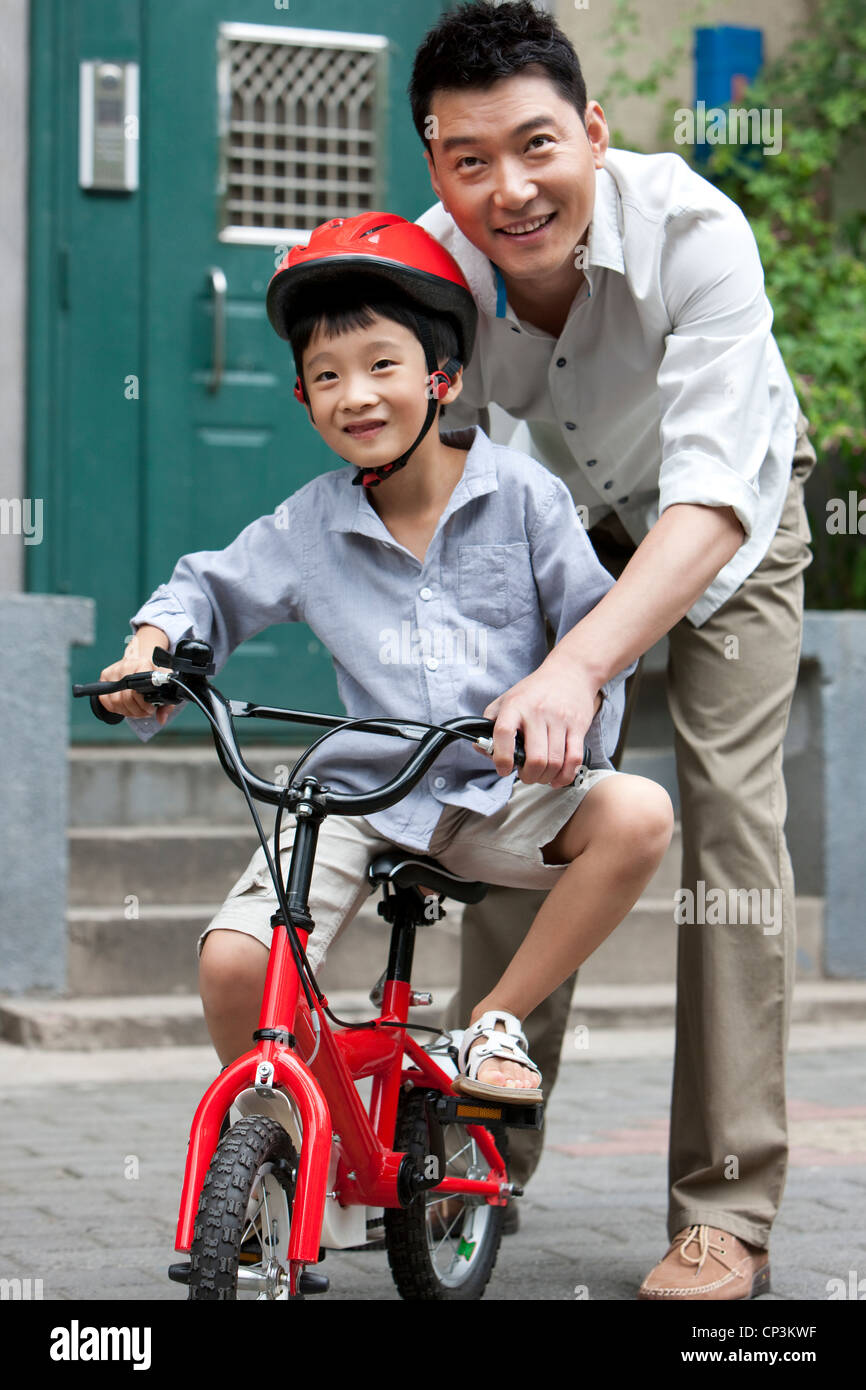 Father helping son ride a bike hi-res stock photography and images - Alamy