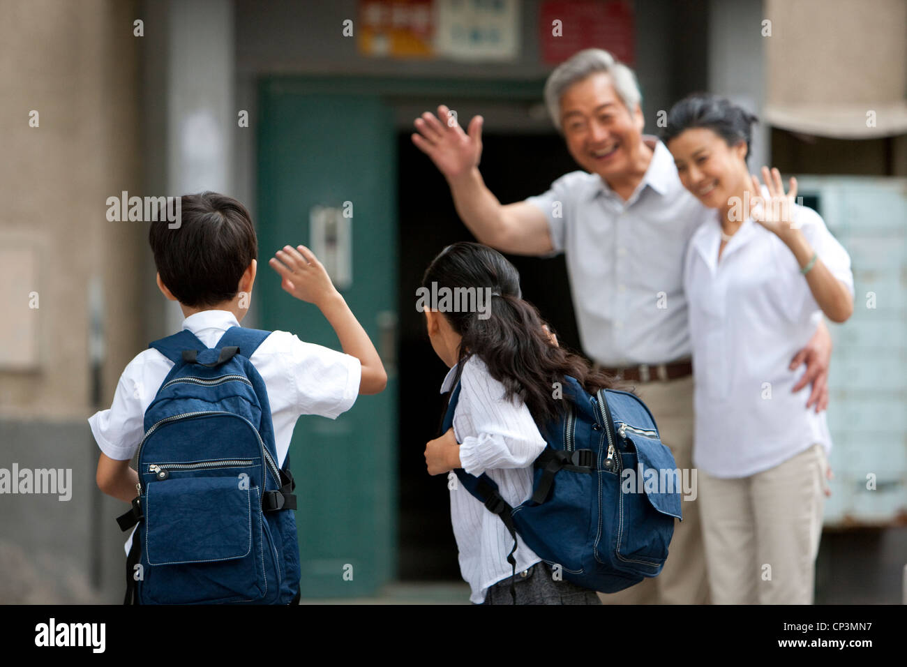 Chinese schoolkids with grandparents waving Stock Photo - Alamy