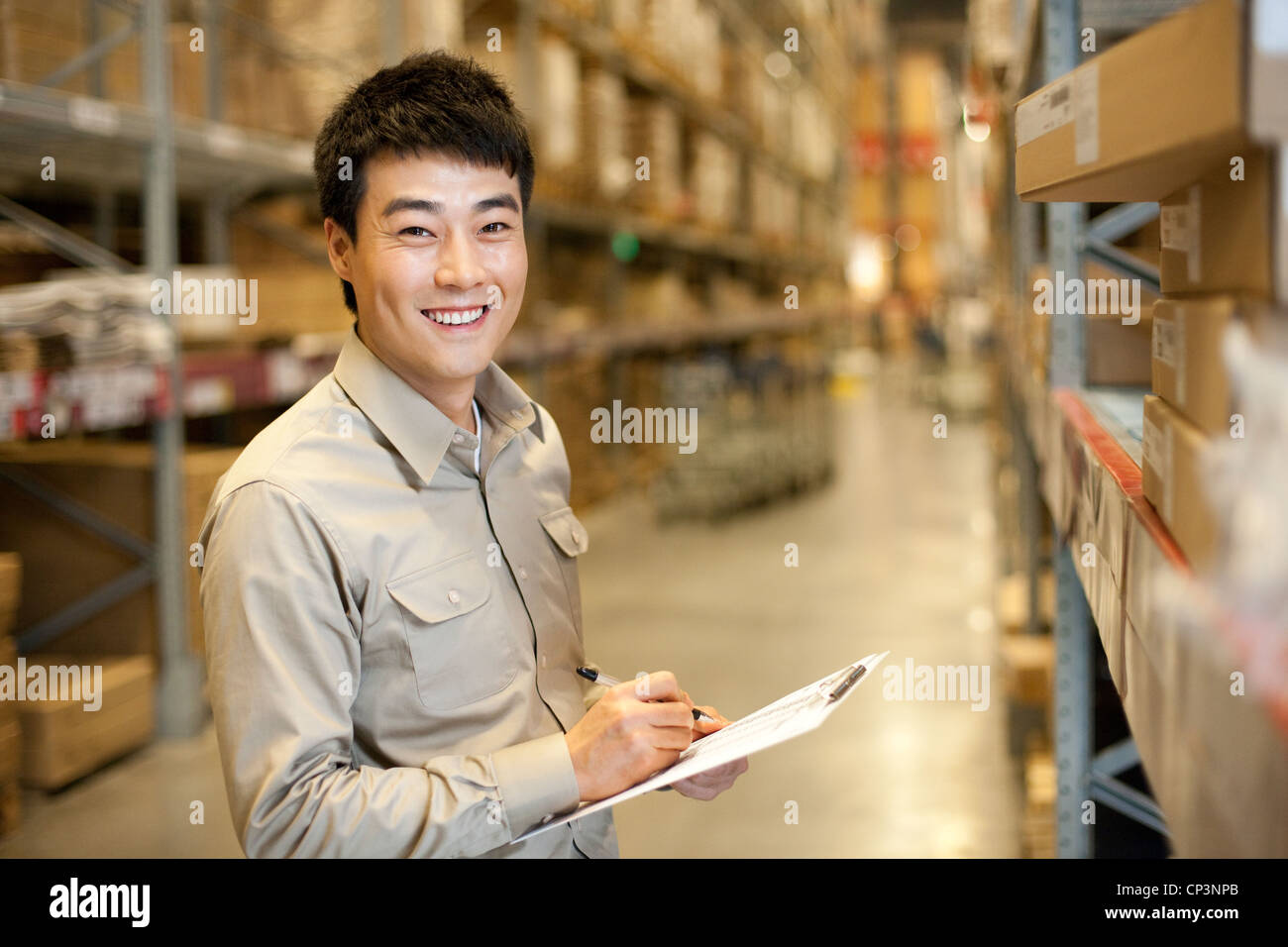 Female Chinese warehouse worker with clipboard and walkie-talke Stock ...