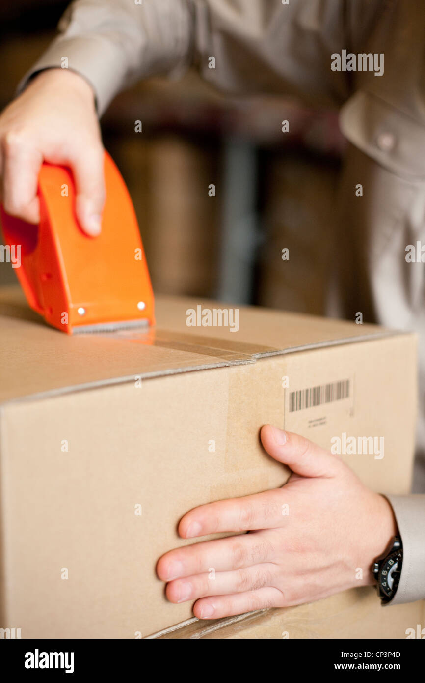 Male Chinese warehouse worker packing a box Stock Photo - Alamy