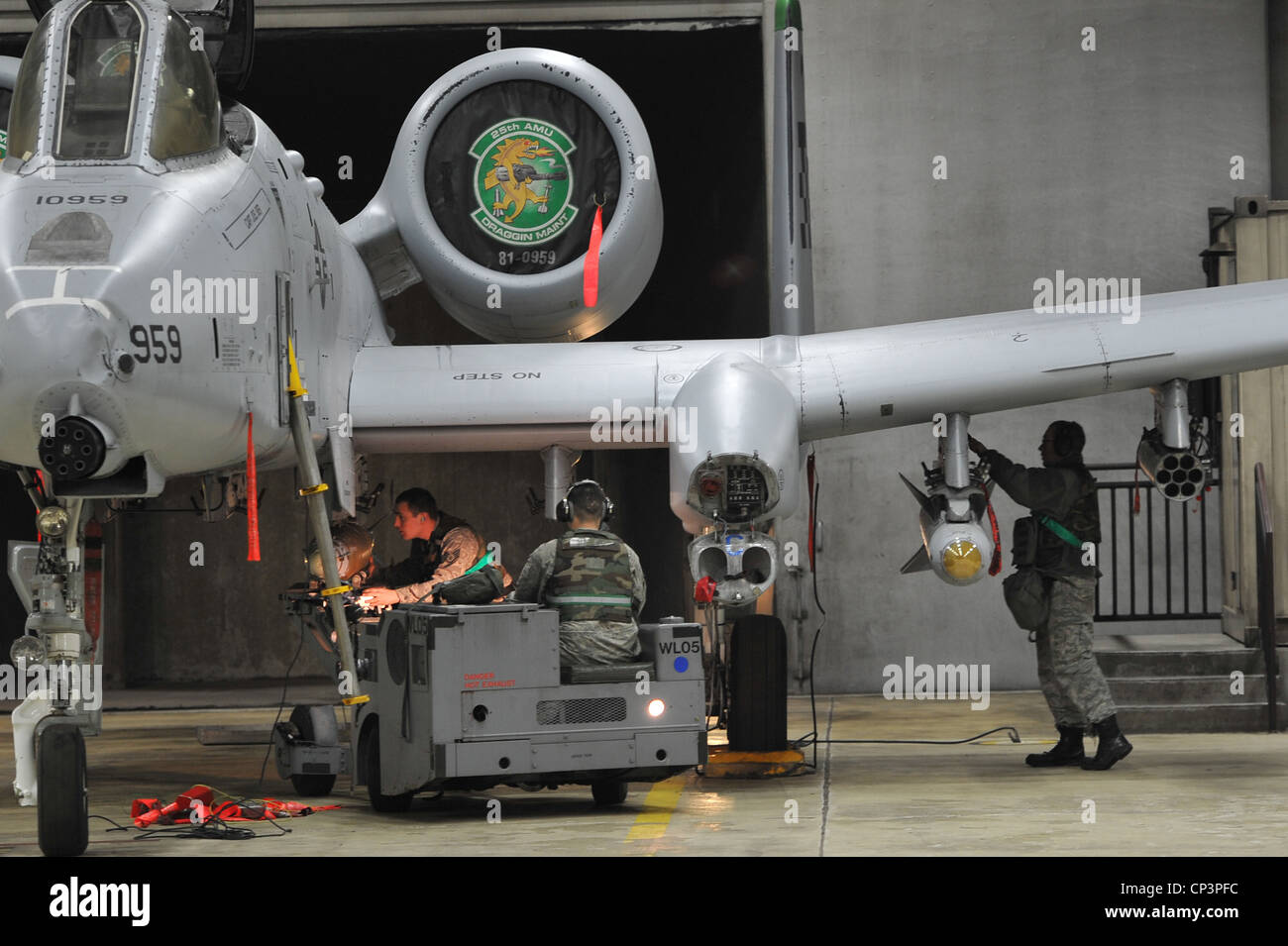 Members of the 25th Aircraft Maintenance Unit load munitions onto an A ...
