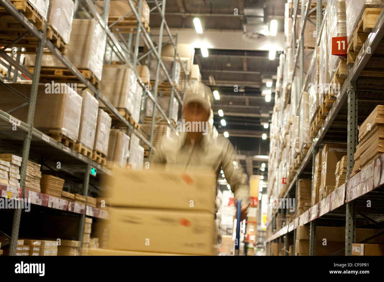 Blurred motion shot of Chinese warehouse worker pushing boxes Stock ...