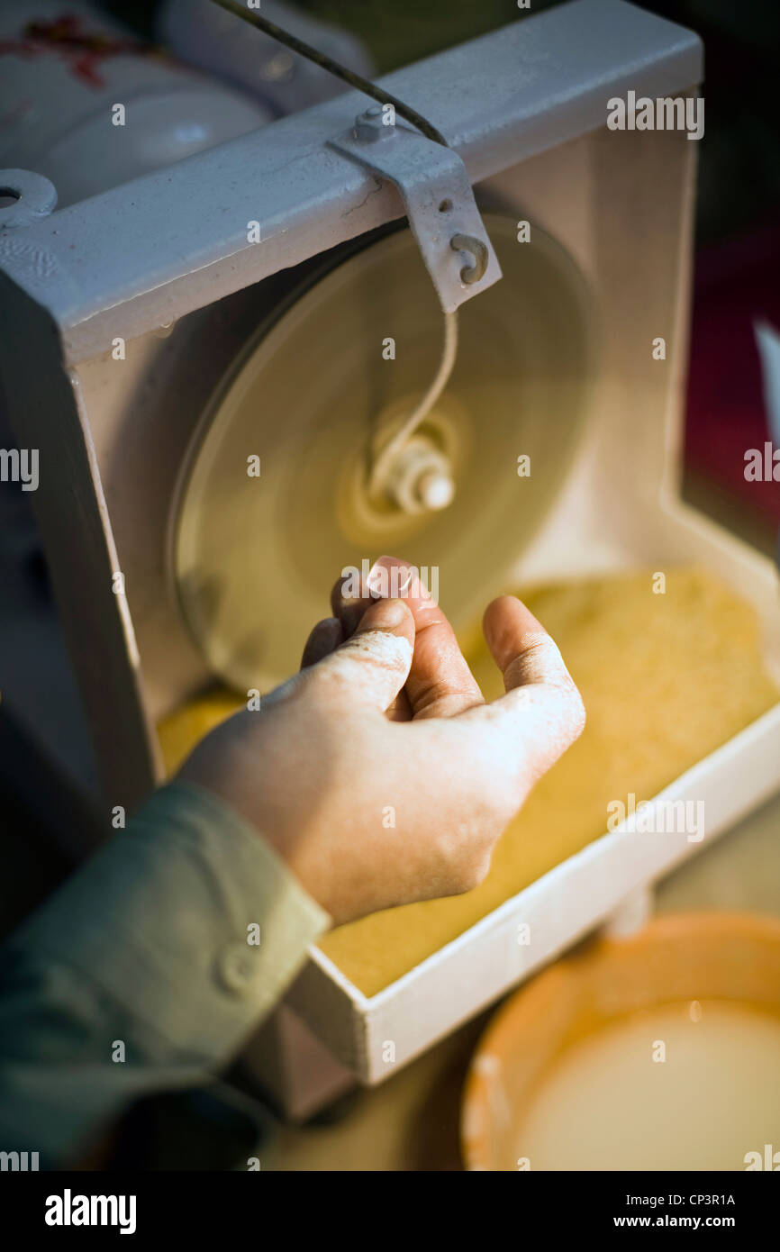A worker polishing and measuring gem stones in a workshop at the Gem ...