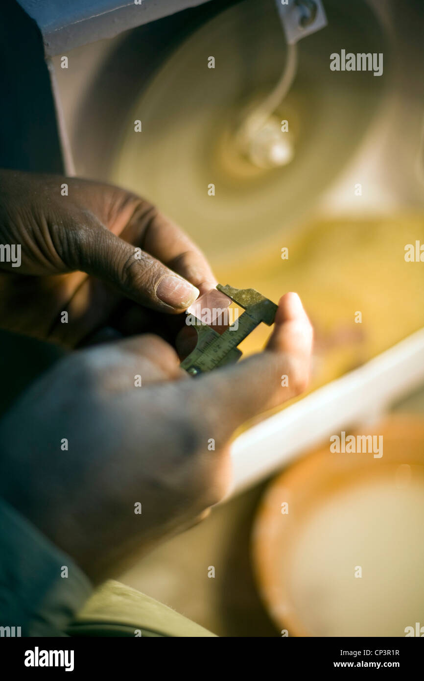 A worker polishing and measuring gem stones in a workshop at the Gem ...