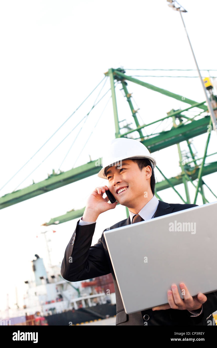 businessman using a laptop and mobile phone at a shipping port Stock ...