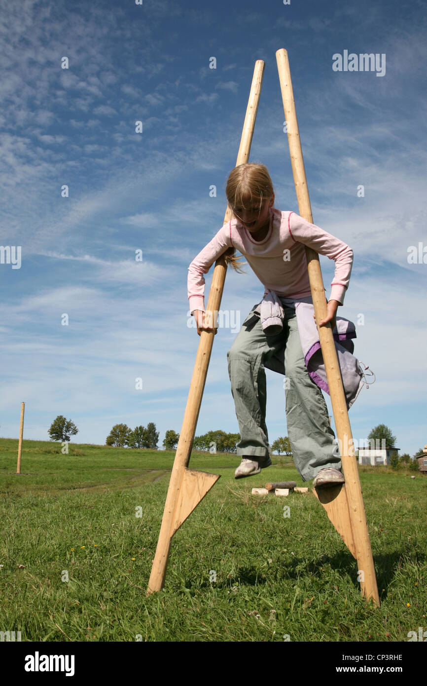 Young girl walking on stilts in the Kizhi Open air Museum on Onega Lake ...