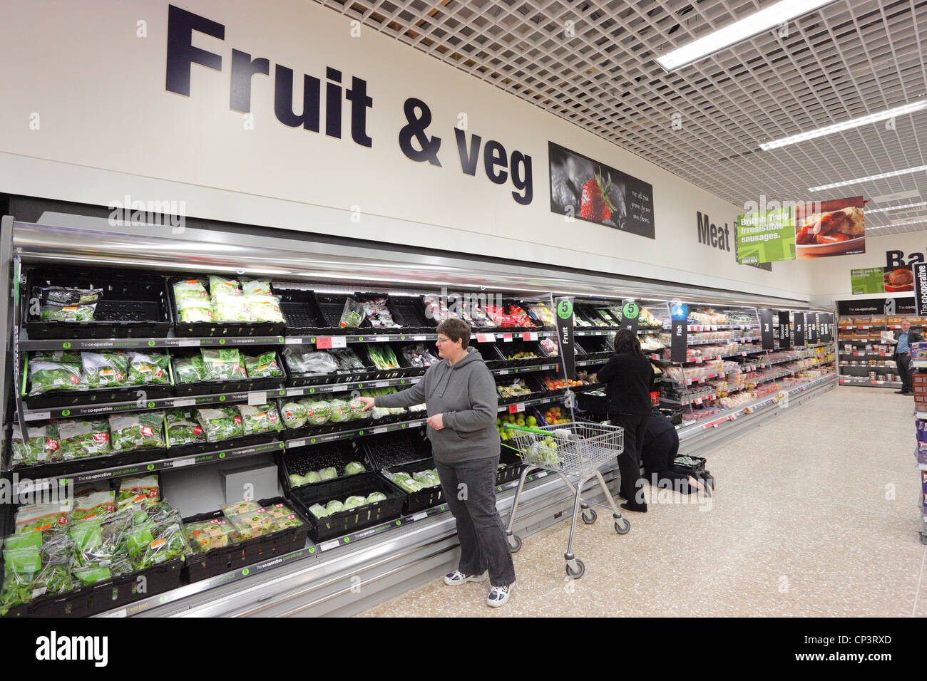 Woman shopping in a supermarket Fruit and vegetable aisle Stock Photo ...