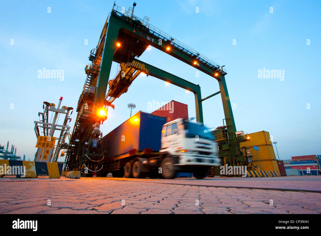 Blurred motion of truck with cargo containers and cranes in a shipping ...