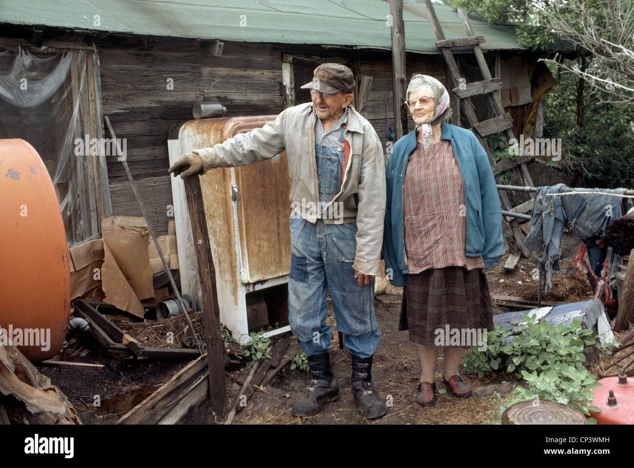 Old woman and old man in front of their very poor dilapidated shack ...