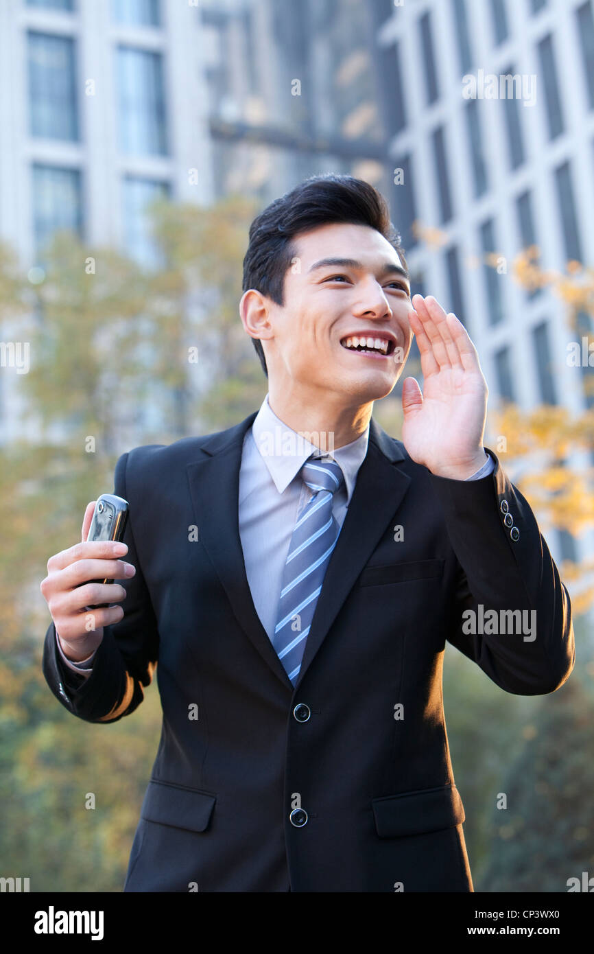 Businessman calling people outside Stock Photo - Alamy