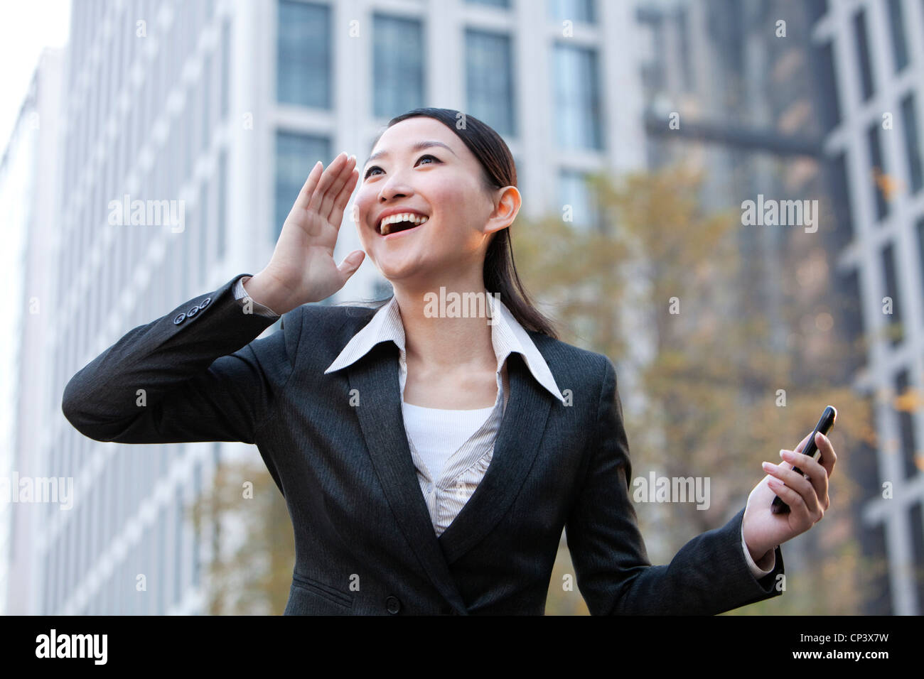 Businesswoman outside office buildings yelling Stock Photo - Alamy
