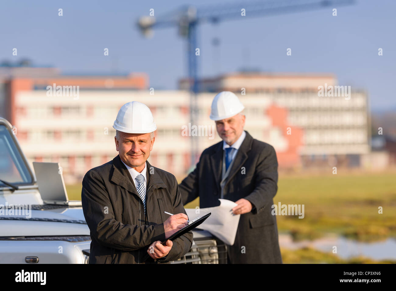 Male architect developers on construction site making notes building ...