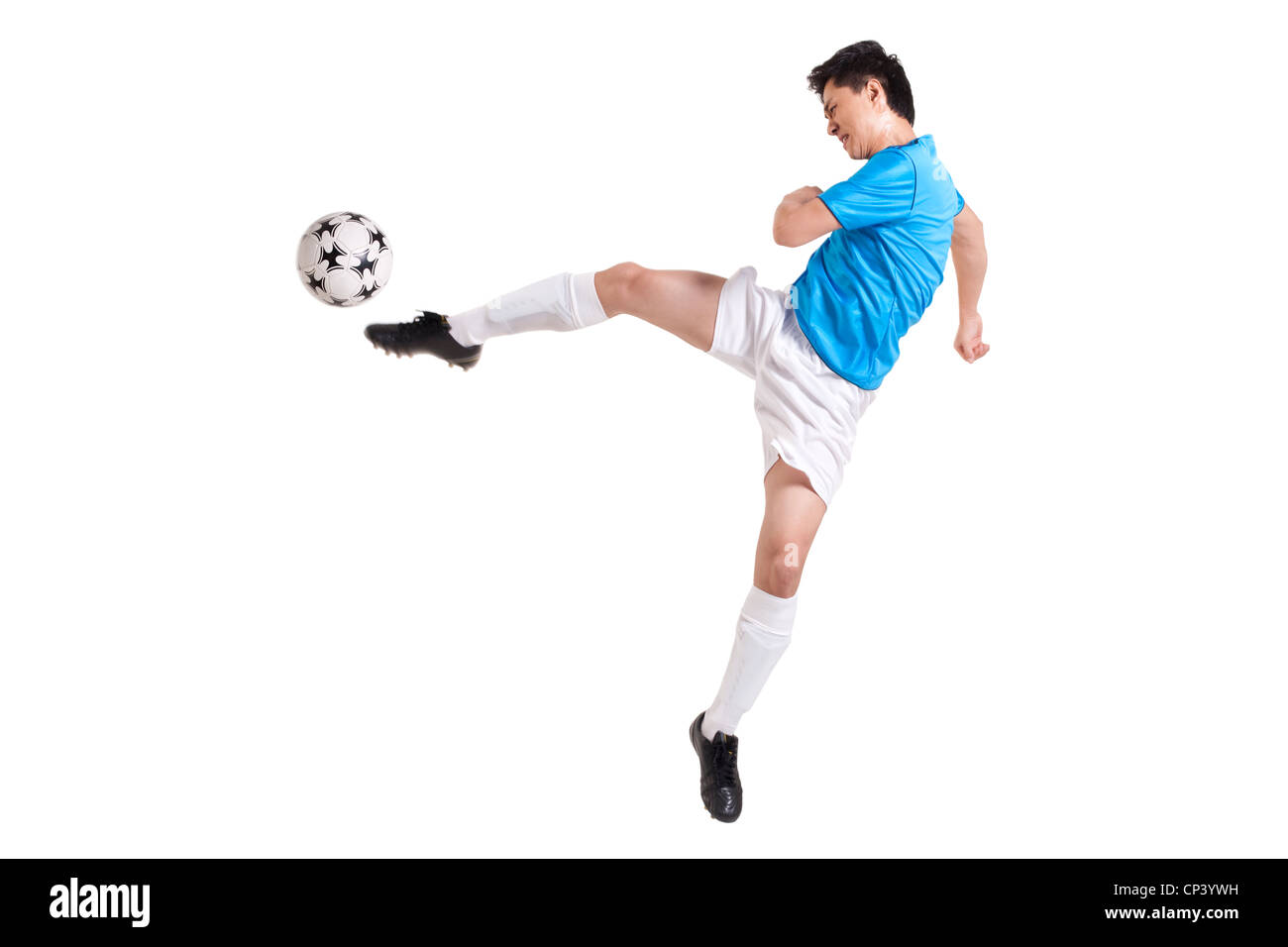 Soccer player kicking while jumping Stock Photo - Alamy