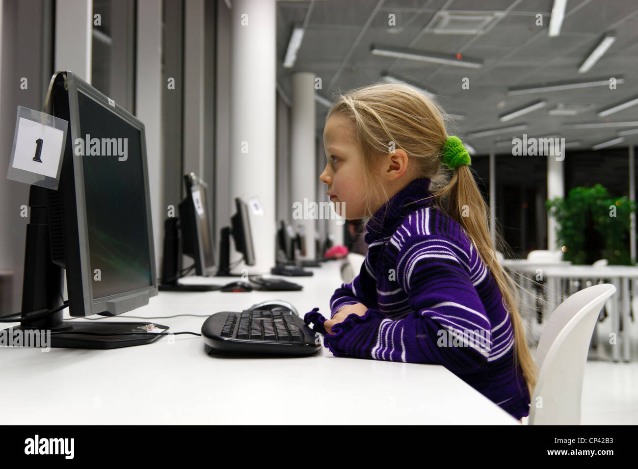 serious little girl used a public library computer Stock Photo - Alamy