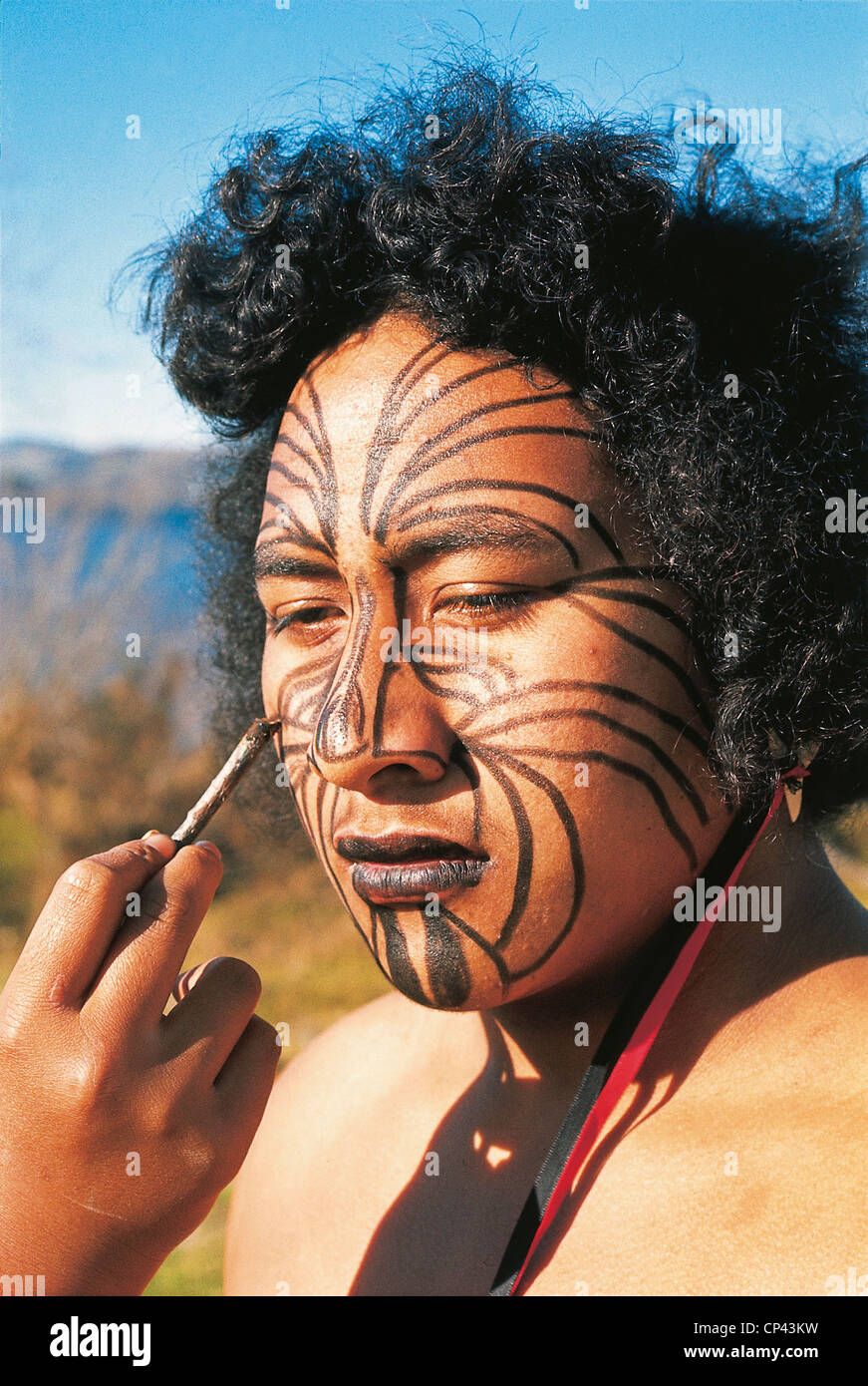 NEW ZEALAND YOUNG PAINTING WITH THE TECHNIQUE OF Moko Stock Photo - Alamy
