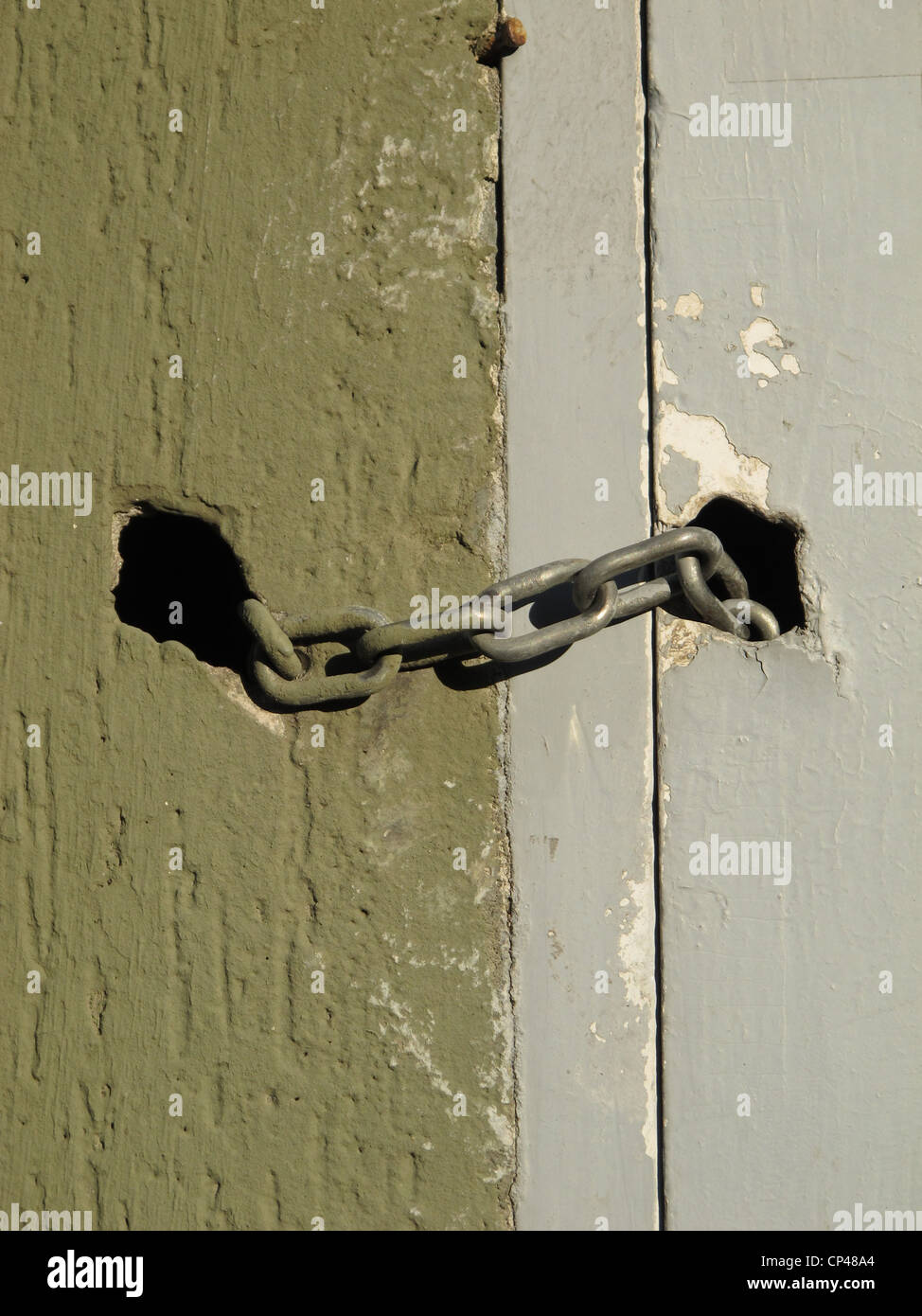 improvised chain lock on old door Stock Photo - Alamy