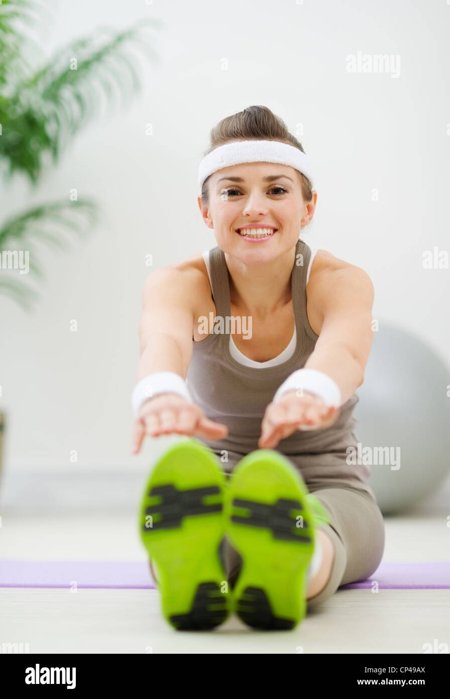 Happy fitness woman doing leg stretching exercises Stock Photo - Alamy