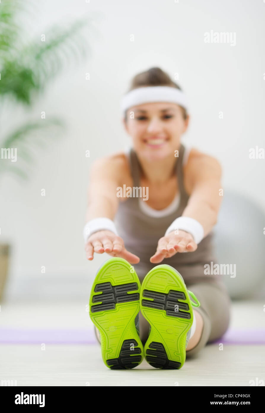 Slim woman doing leg stretching exercises. Focus on sneakers Stock ...