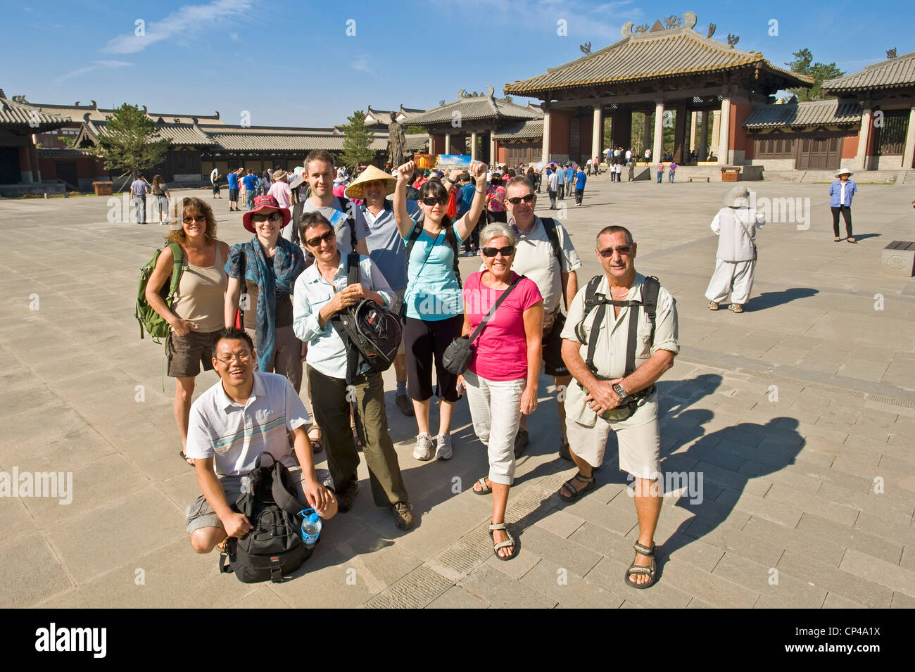 A group of western tourists pose at the entance to the Yungang Grottoes ...