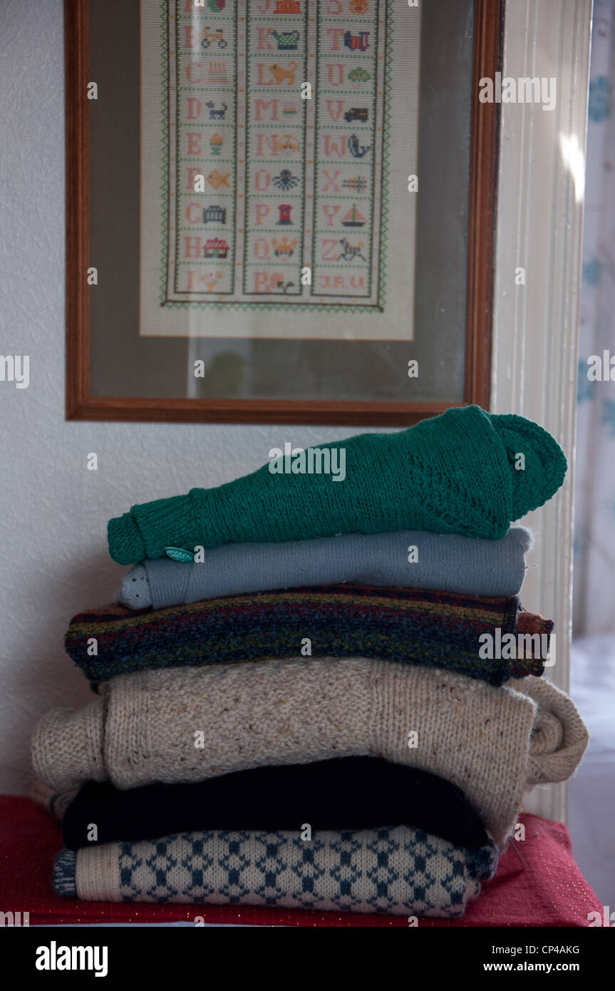 A stack of woolen jumpers in a home setting Stock Photo - Alamy