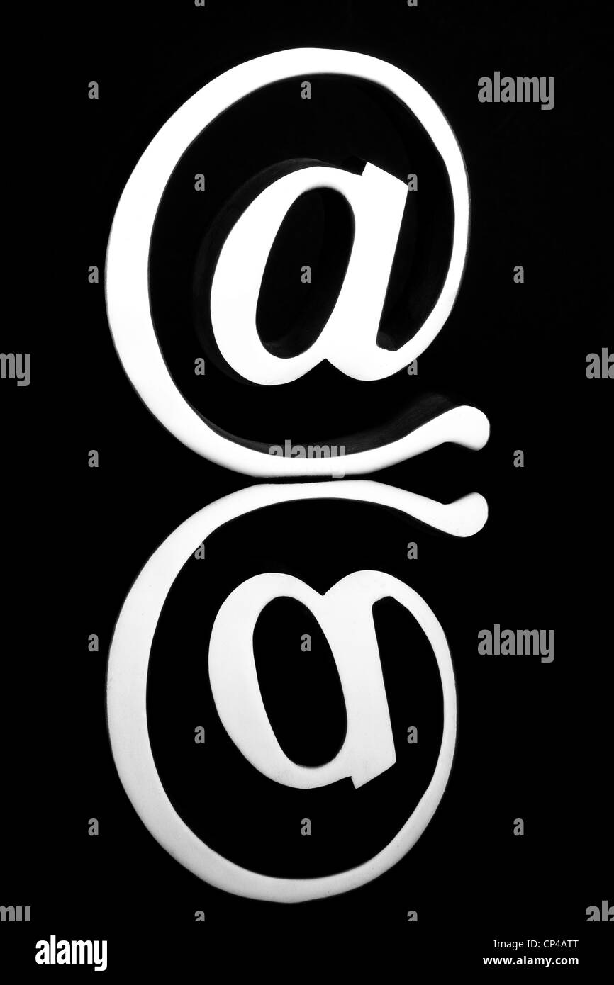 At symbol paperweight on reflective surface Stock Photo - Alamy