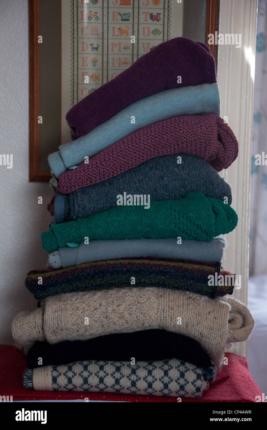 A stack of woolen jumpers in a home setting Stock Photo - Alamy