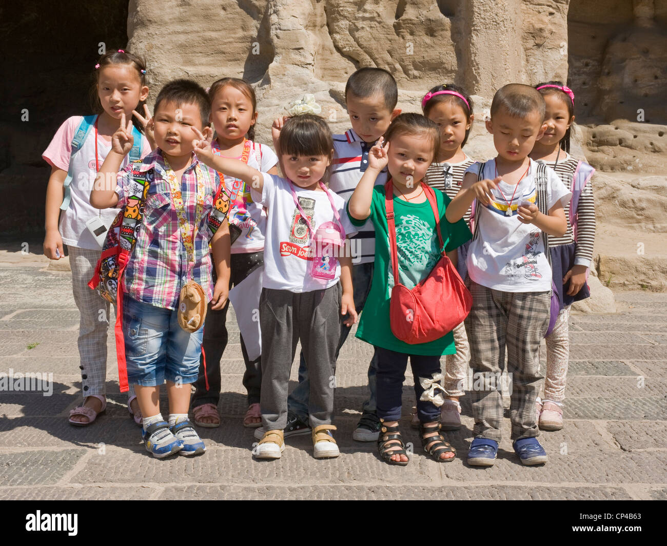 A group of young Chinese school children visiting the Yungang Grottoes ...