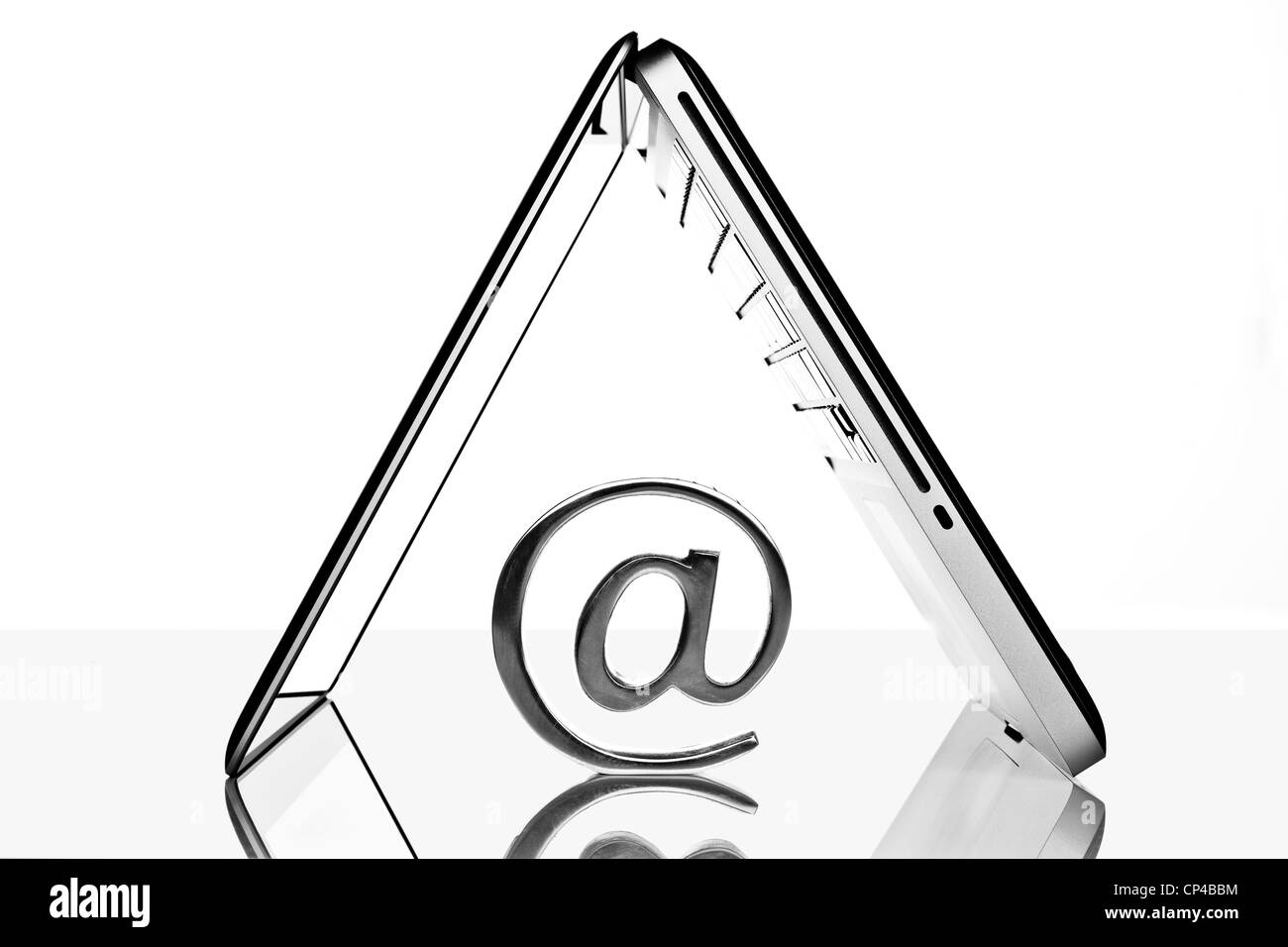 At symbol paper weight with laptop computer Stock Photo - Alamy