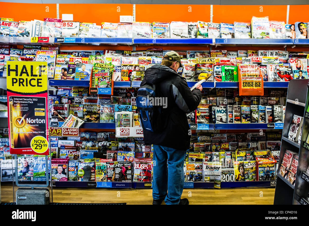 a person browsing the magazines and periodicals at a branch of W H ...