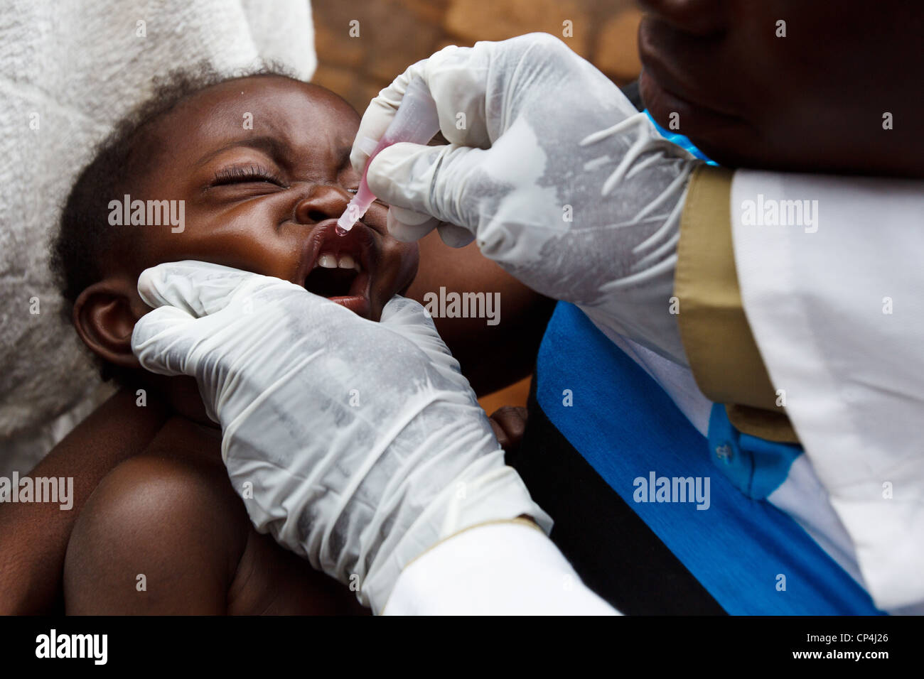 A child receives two drops of polio vaccine during routine vaccination ...