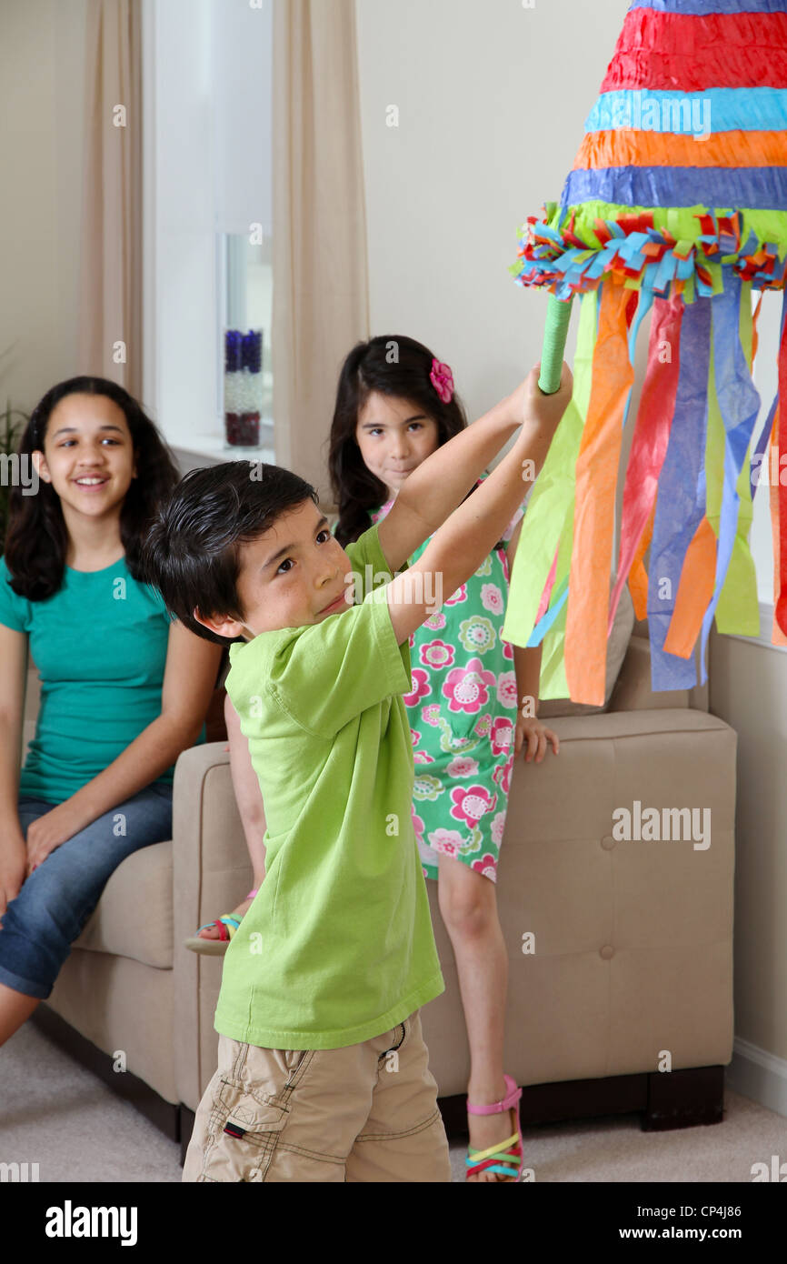 Kids hitting a piñata at birthday party Stock Photo - Alamy