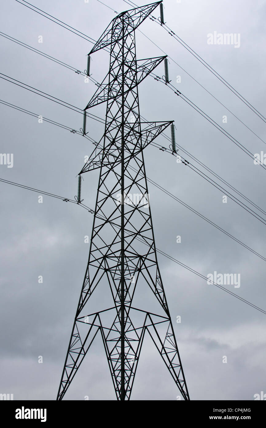 An electricity pylon against a dark cloudy sky Stock Photo - Alamy